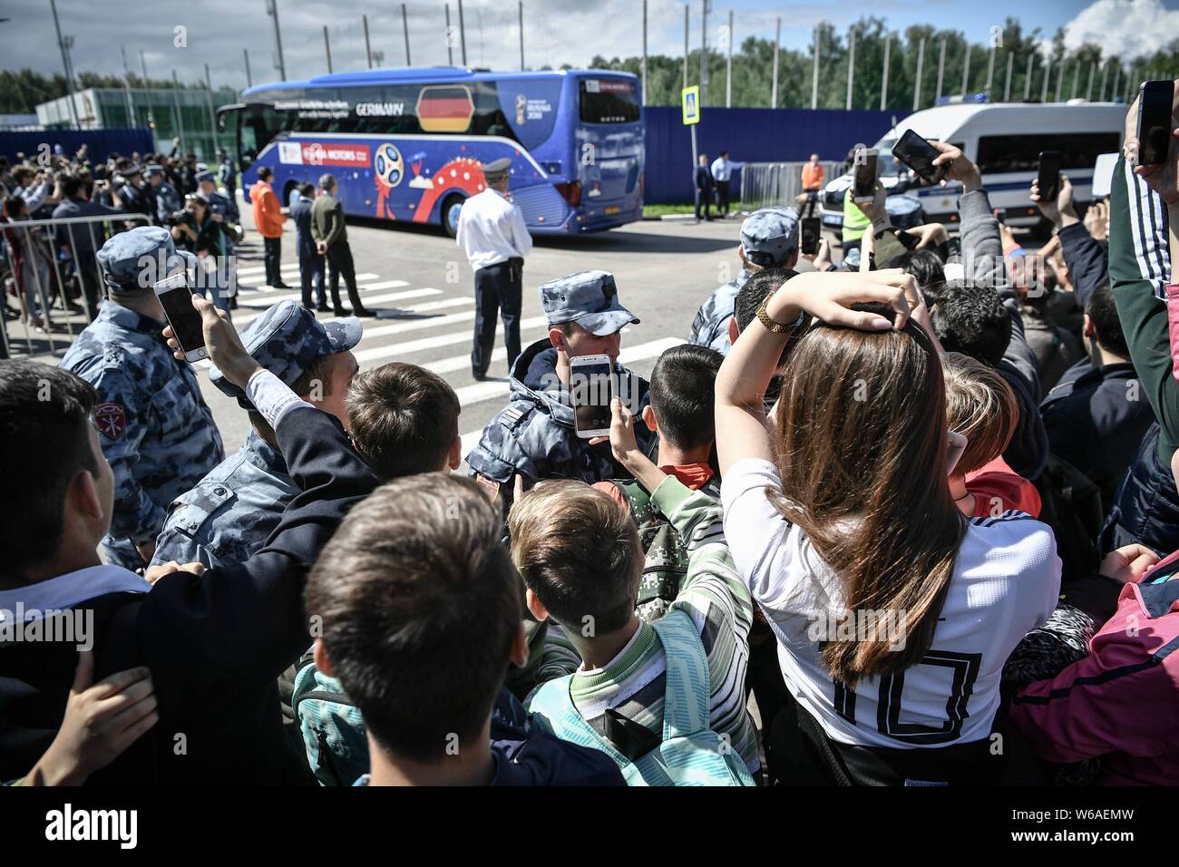 Crowds of football fans take photos of the bus carrying German players ...