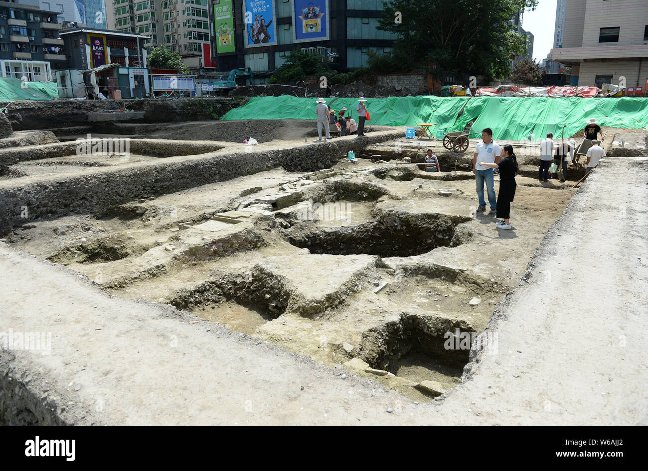 Chinese workers investigate the excavation site of an ancient city ...