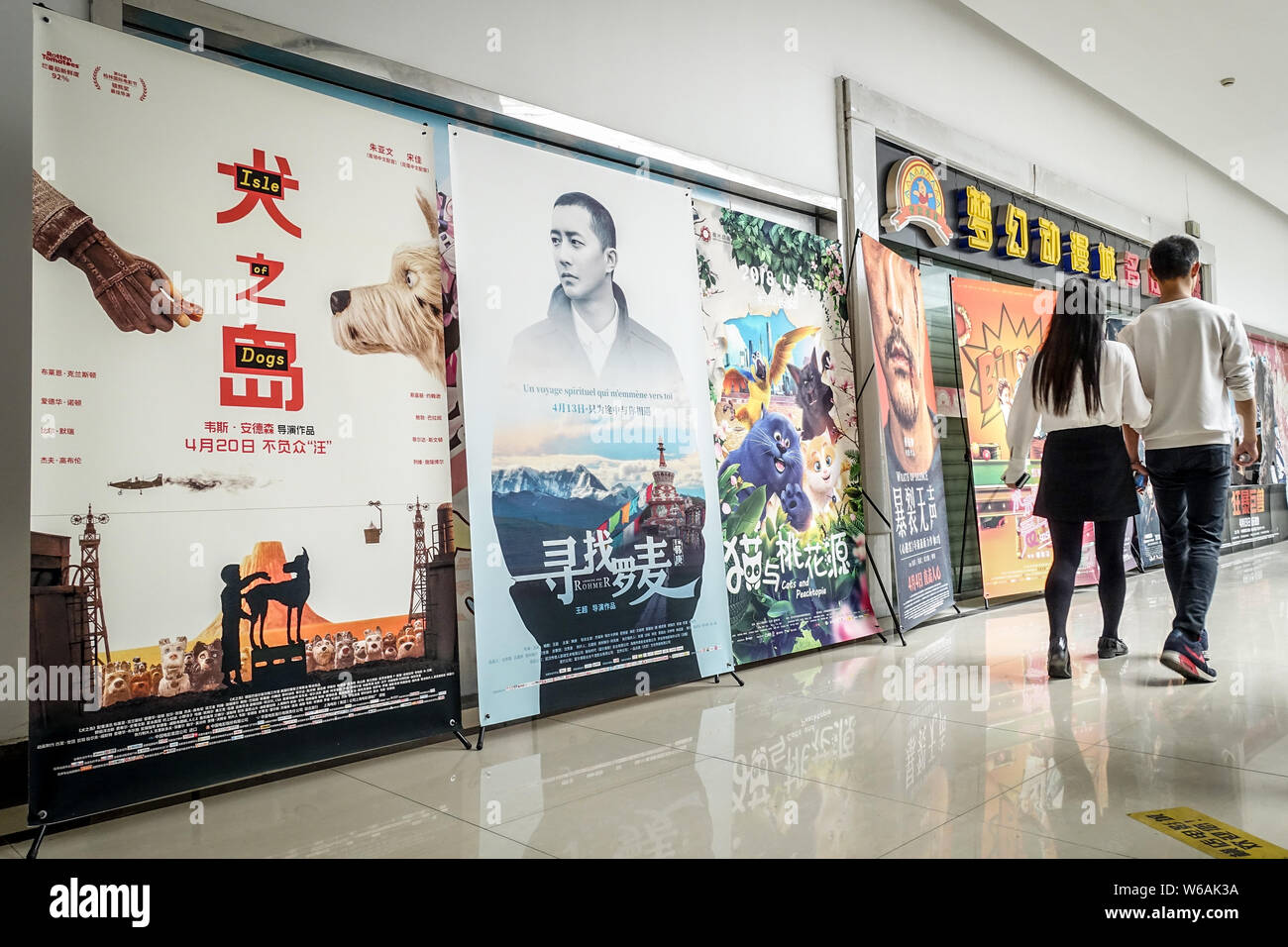 --FILE--Chinese moviegoers walk past posters for movies at a cinema in ...