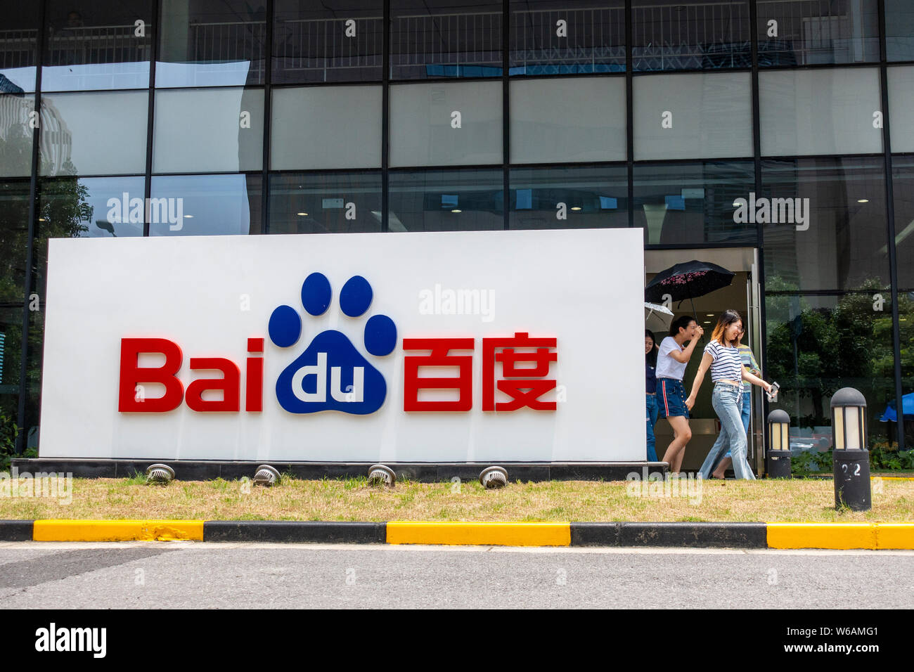 Chinese employees walk out of the office building of Baidu in Shanghai ...