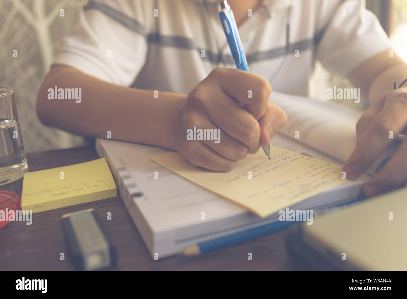Young student studying and writing into notes Stock Photo - Alamy