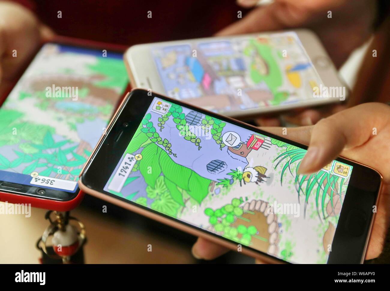 --FILE--A Chinese player "raises" a frog as she plays mobile game "Tabi ...