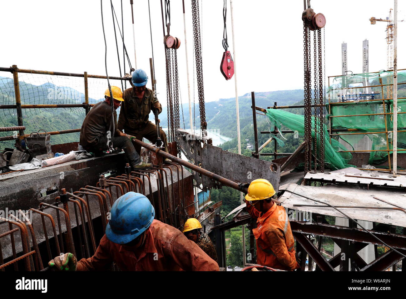 Chinese workers labor at the construction site of the stayed cable ...