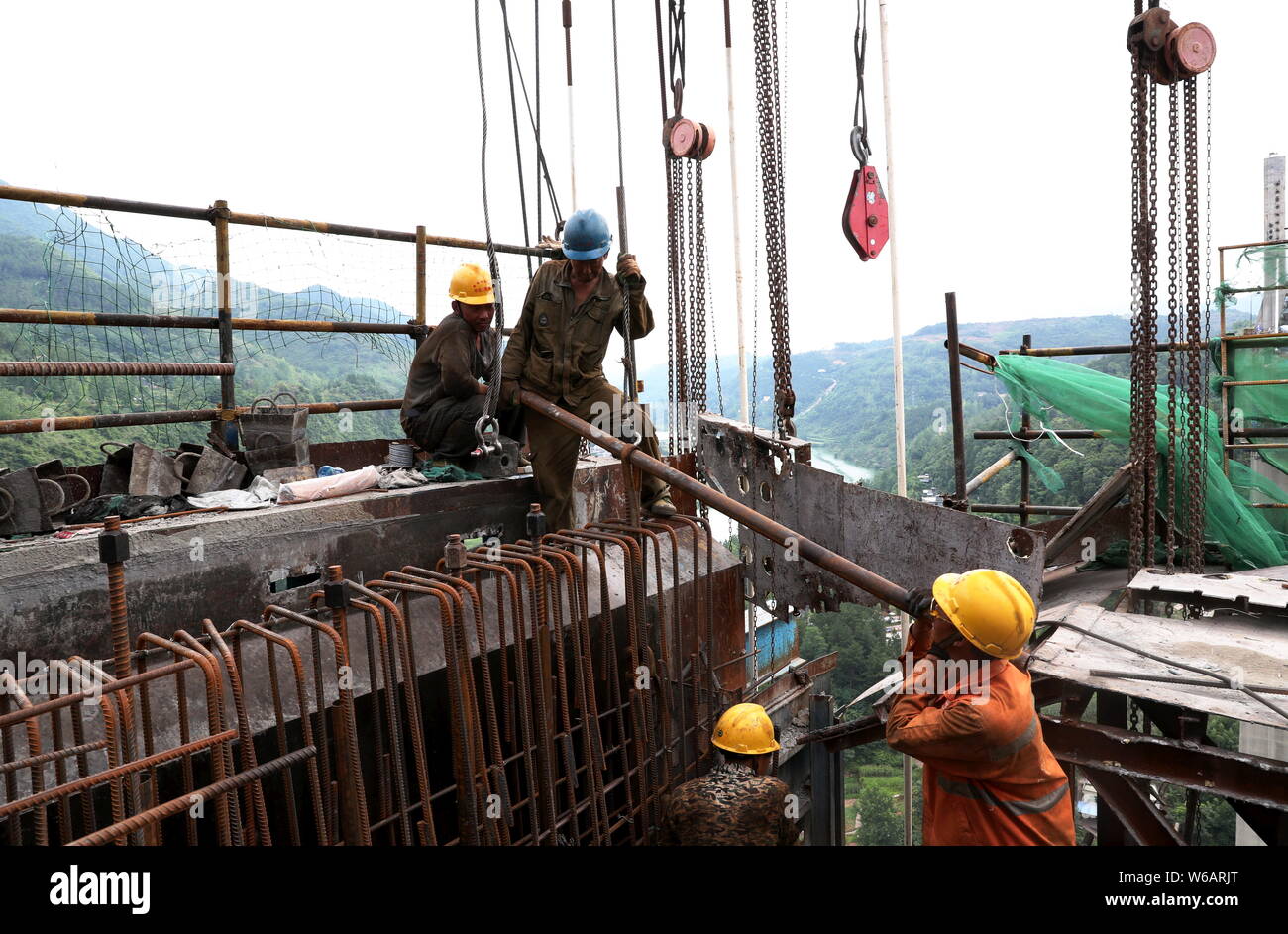 Chinese workers labor at the construction site of the stayed cable ...