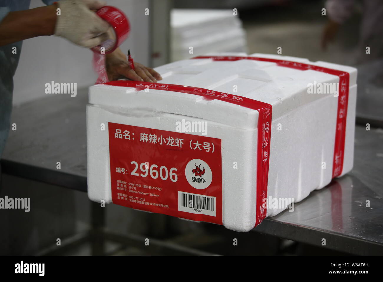 A Chinese worker packages crayfish to be served during the 2018 Russia ...