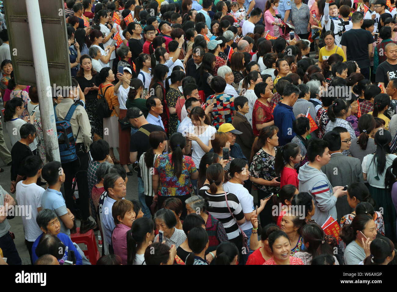 Local Chinese residents and parents crowd the streets to see students ...