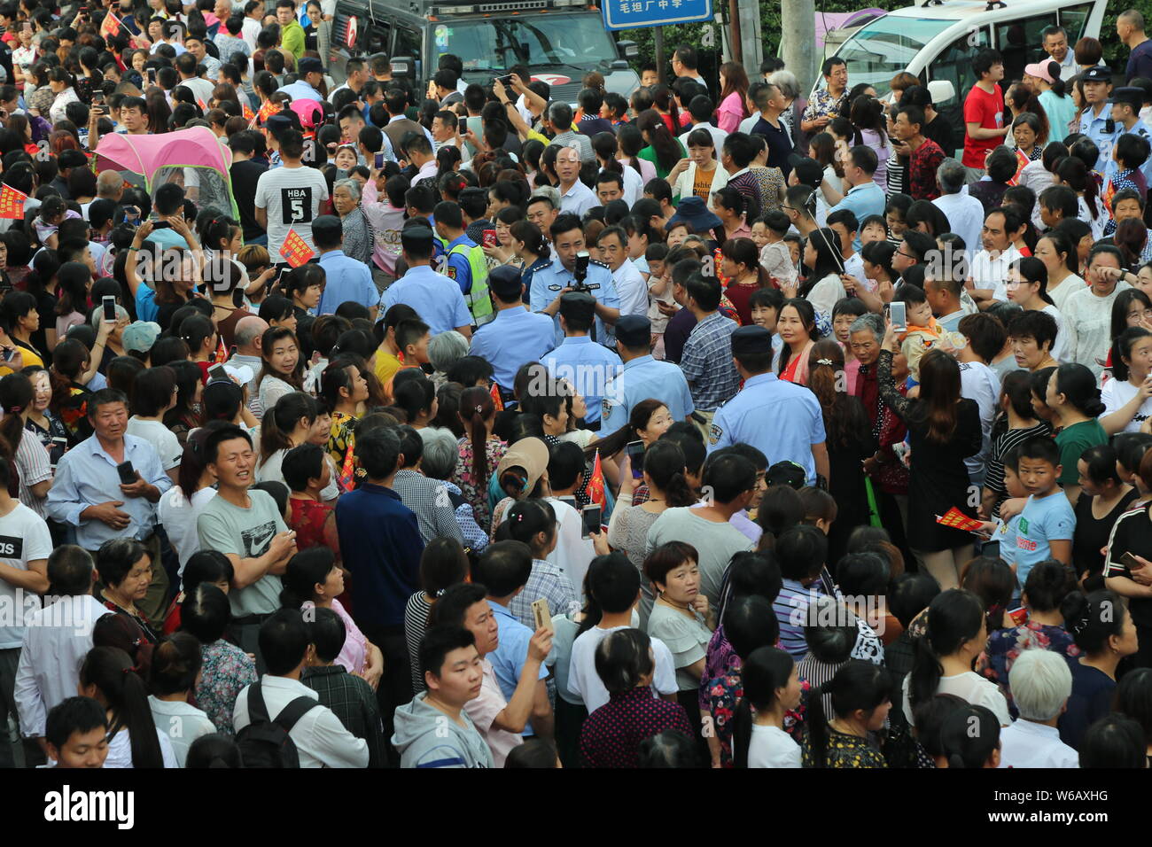 Local Chinese residents and parents crowd the streets to see students ...