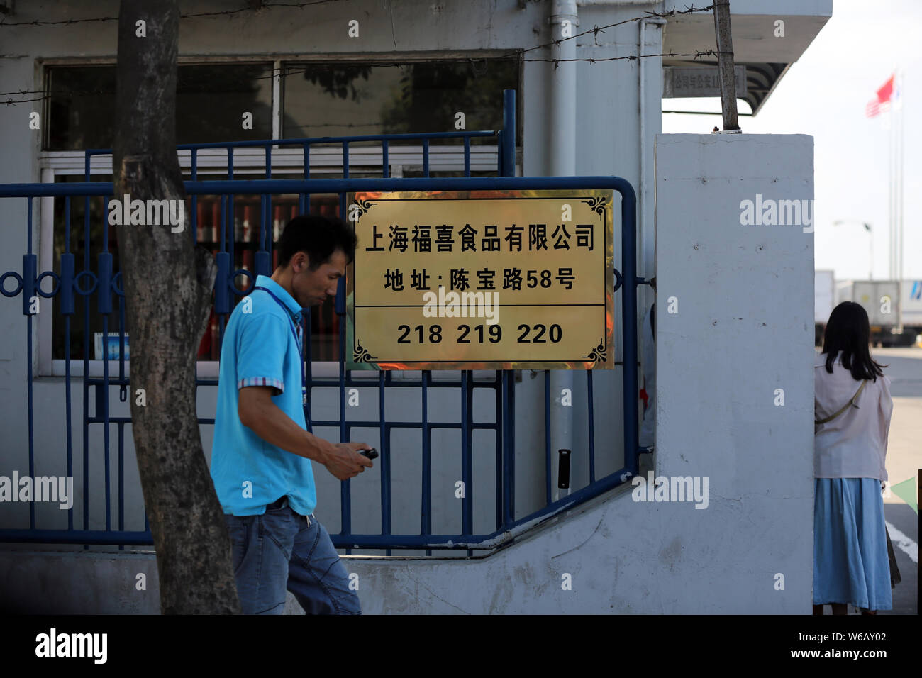 --FILE--A Chinese worker walks past the factory building of Shanghai ...