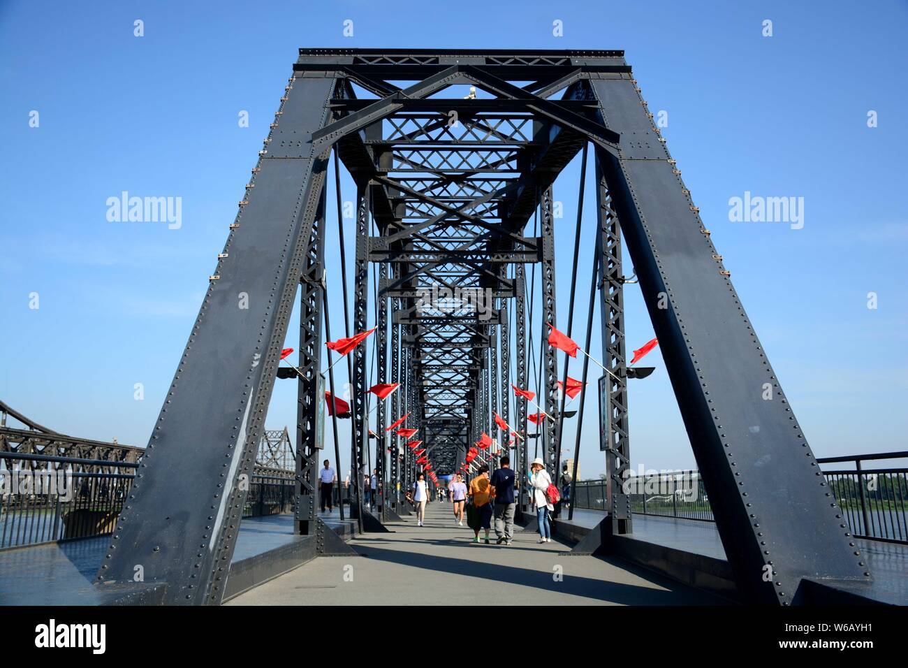 Tourists walk on the Yalu River Broken Bridge over the Yalu River, also ...