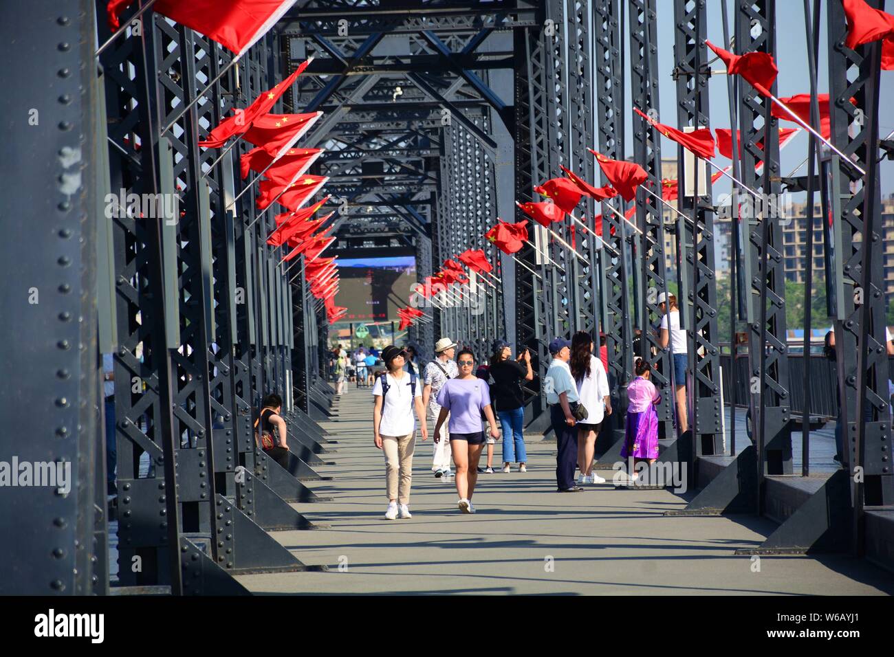 Tourists walk on the Yalu River Broken Bridge over the Yalu River, also ...