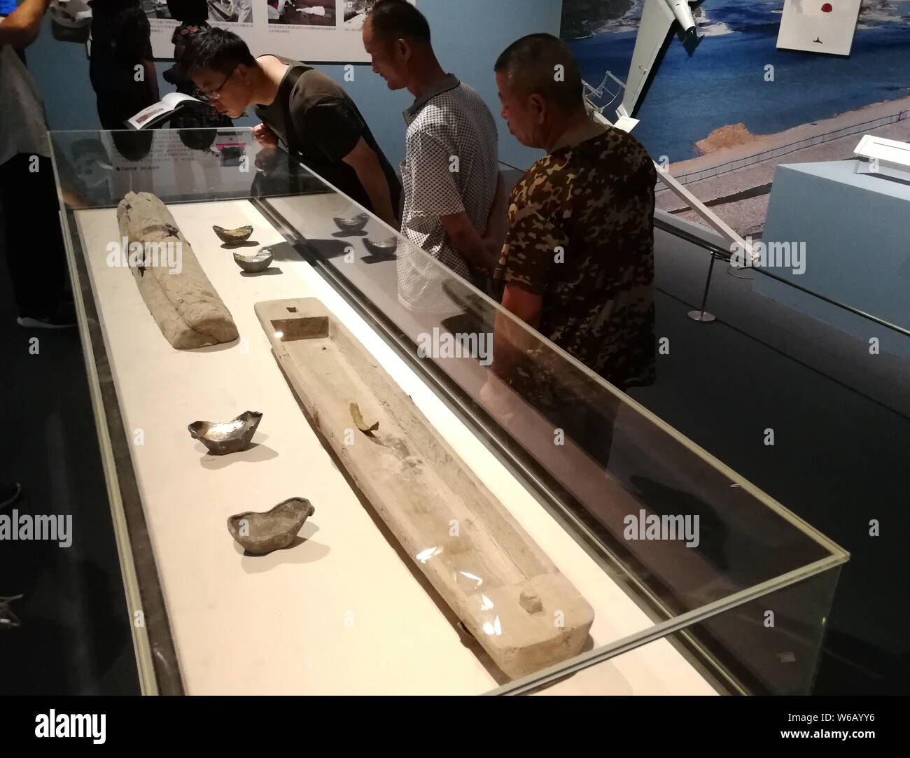 Visitors look at silver ingots unearthed from the sunken boats owned by ...