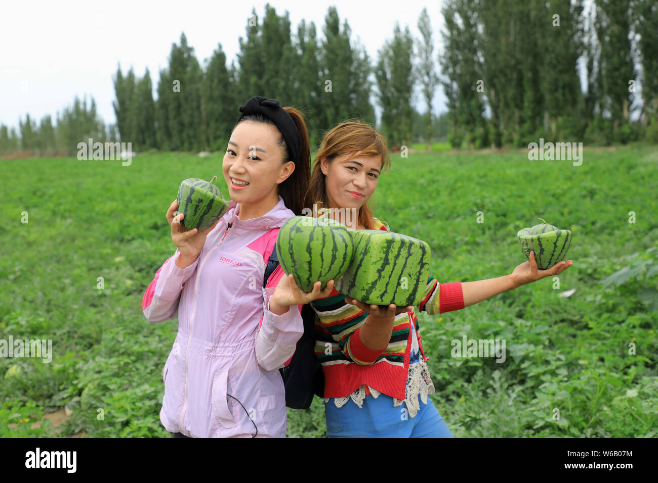 Tourists pose for photos with watermelons featuring the shape of sycee ...