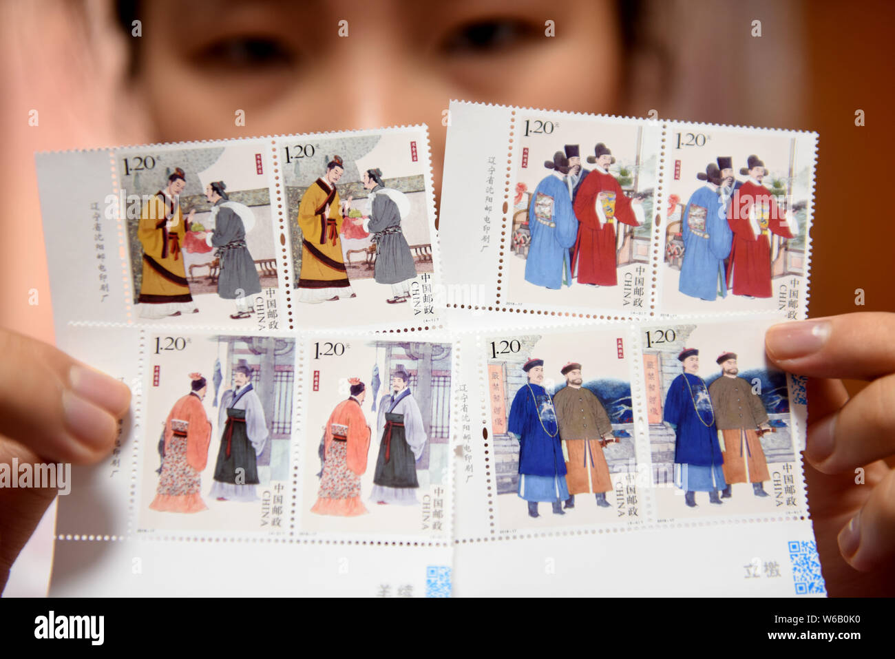 A Chinese stamp collector shows stamps from the stamp set with the ...