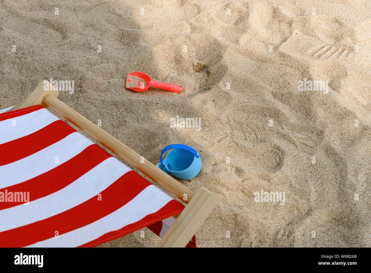 sun lounger and plastic digger in the shade on sand Stock Photo - Alamy