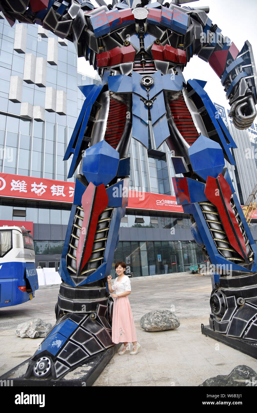 A Chinese woman poses for photos with a replica of Optimus Prime made ...