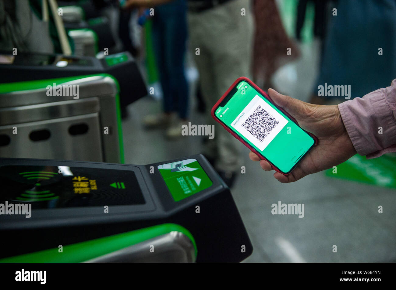 A passenger uses her smartphone to have the QR code through Tencent's ...