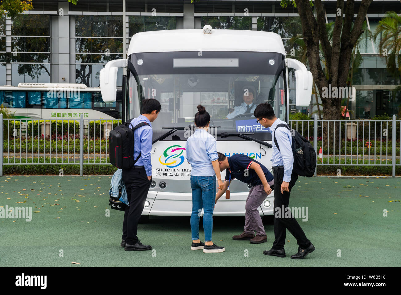 Visitors look at an Alphabus smart bus with self-driving bus technology ...