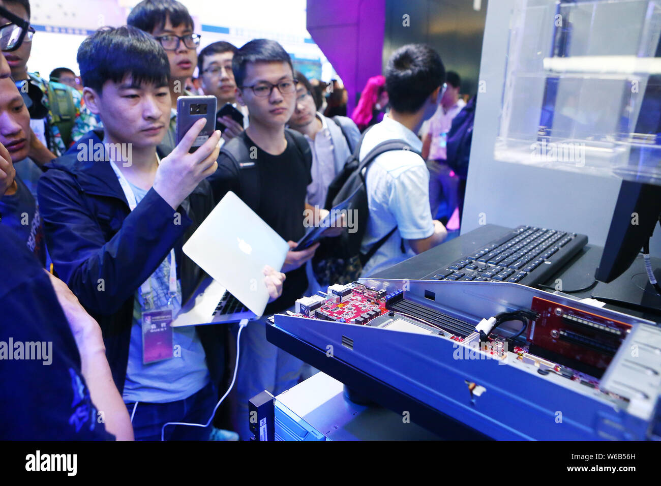 A visitor takes photos of chips developed by Aliyun, the online cloud ...