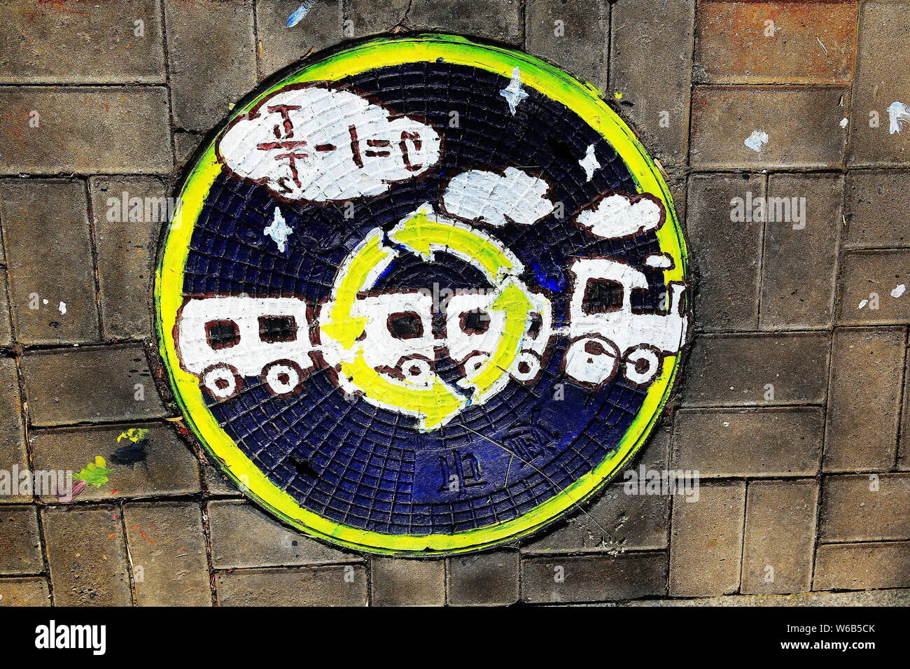 A manhole cover is decorated with special cartoon graffiti ...