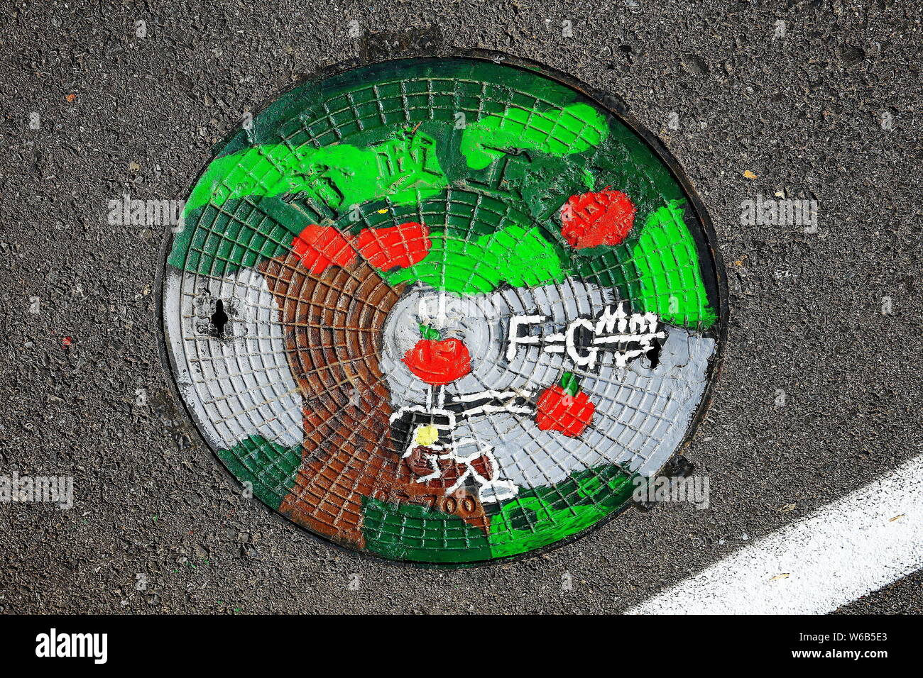 A manhole cover is decorated with special cartoon graffiti ...