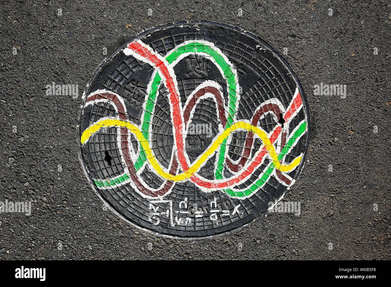 A manhole cover is decorated with special cartoon graffiti ...