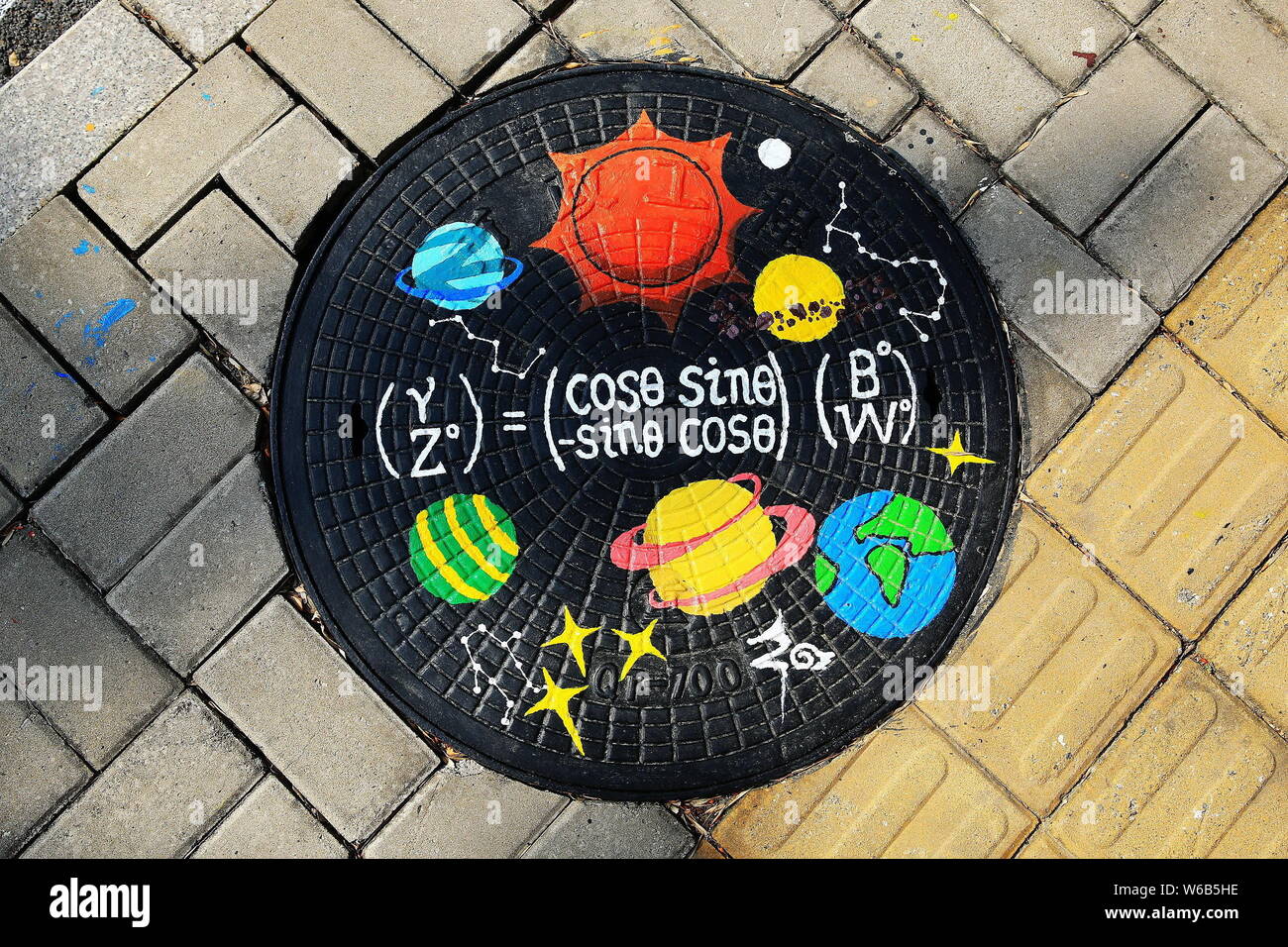 A manhole cover is decorated with special cartoon graffiti ...