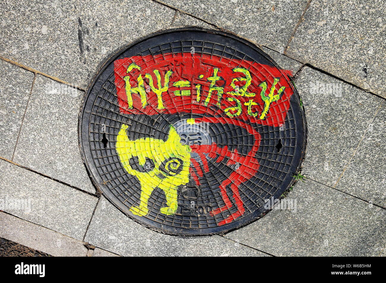 A manhole cover is decorated with special cartoon graffiti ...