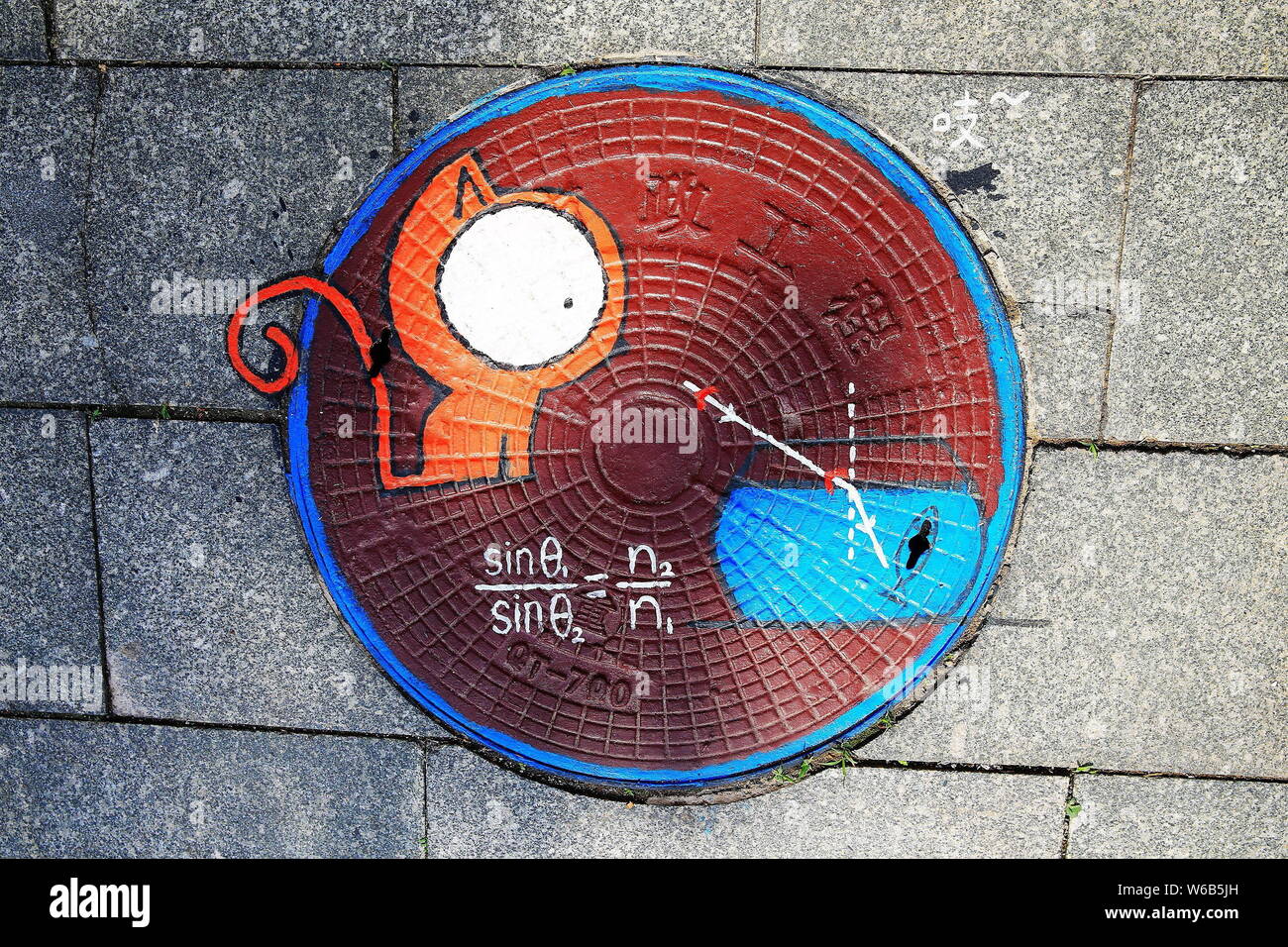 A manhole cover is decorated with special cartoon graffiti ...