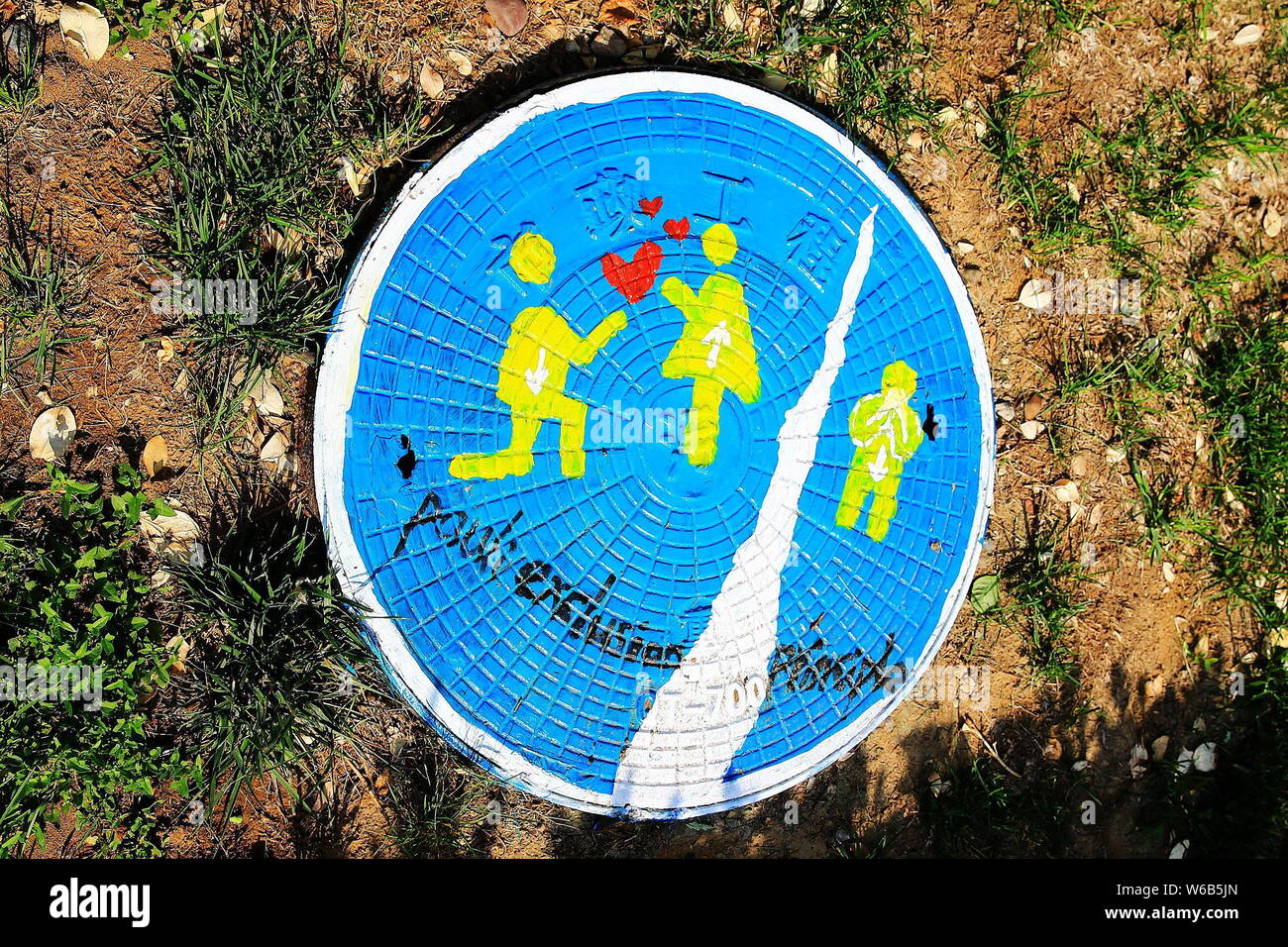 A manhole cover is decorated with special cartoon graffiti ...
