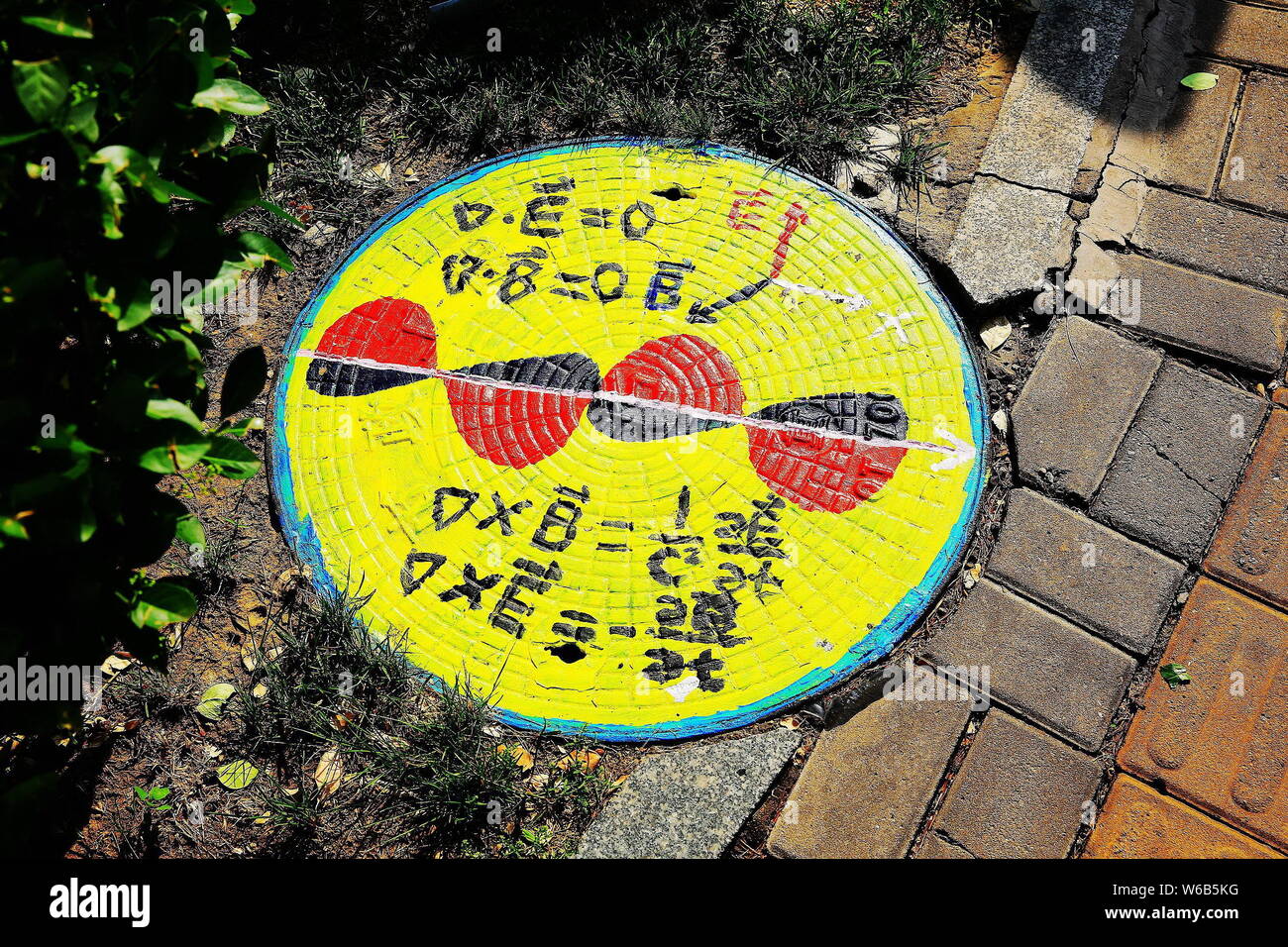 A manhole cover is decorated with special cartoon graffiti ...