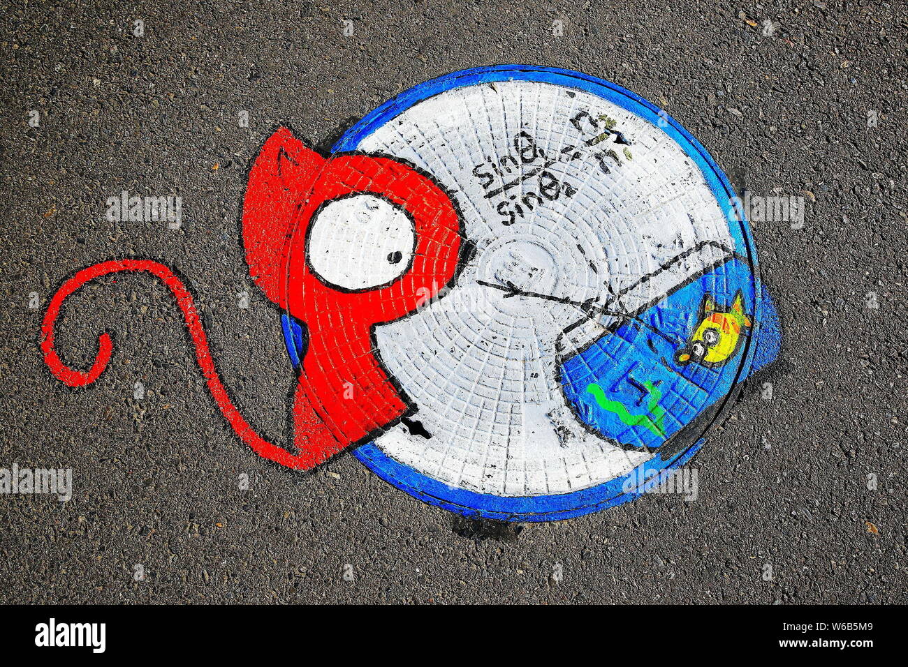A manhole cover is decorated with special cartoon graffiti ...