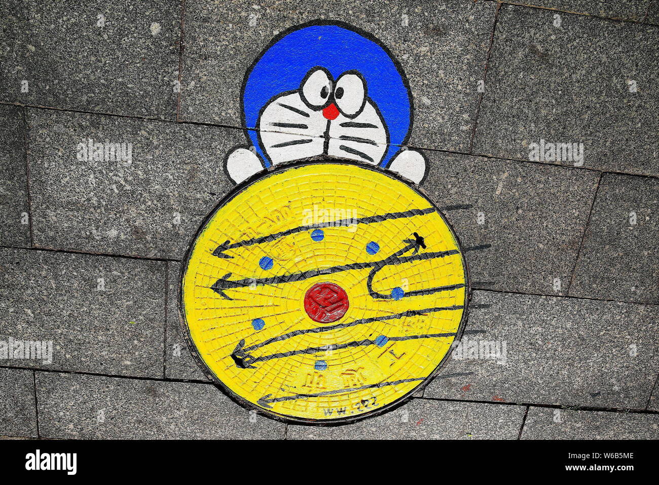 A manhole cover is decorated with special cartoon graffiti ...