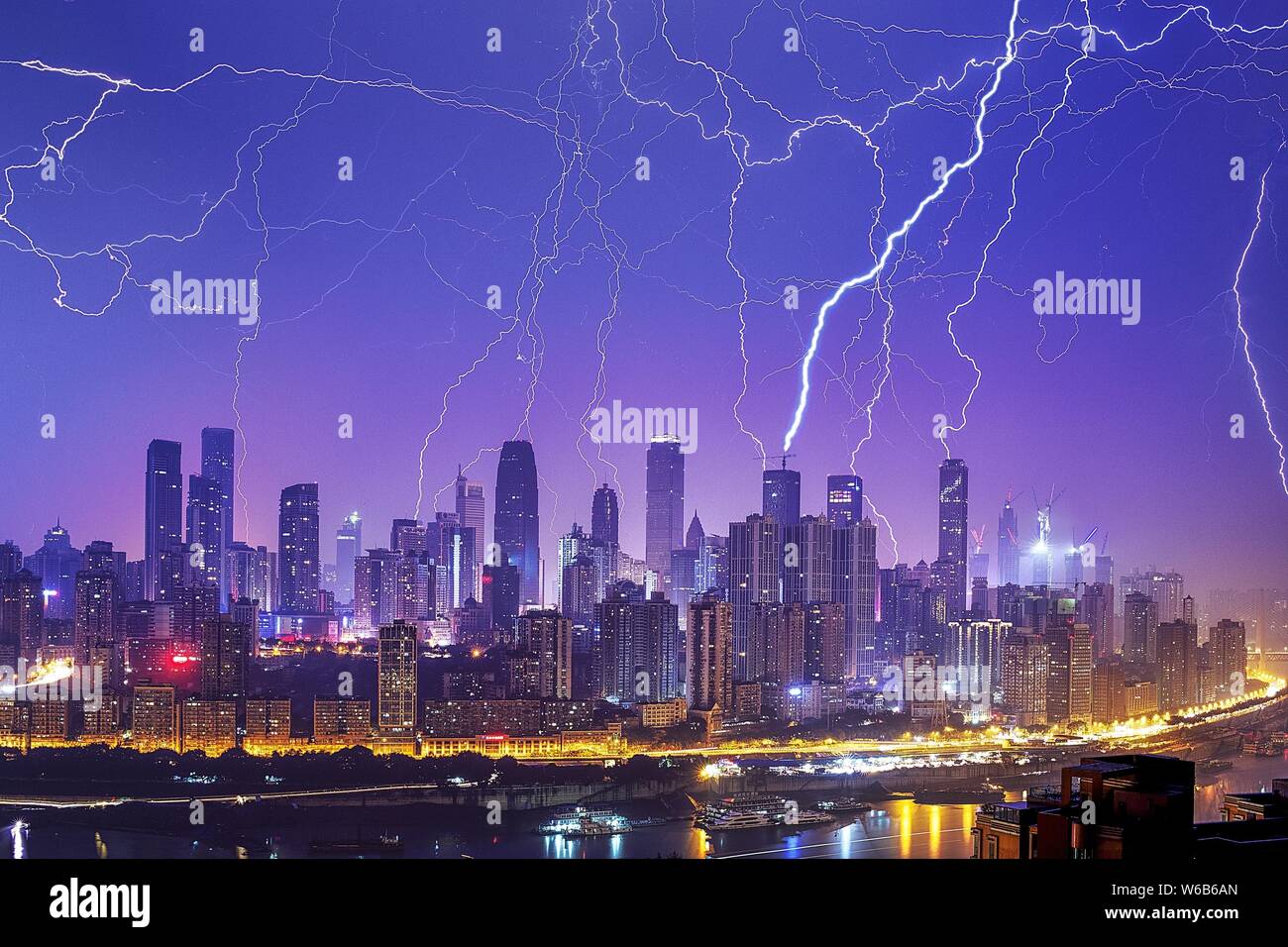 Lightning flashes illuminate the sky over the skyscrapers and high-rise ...