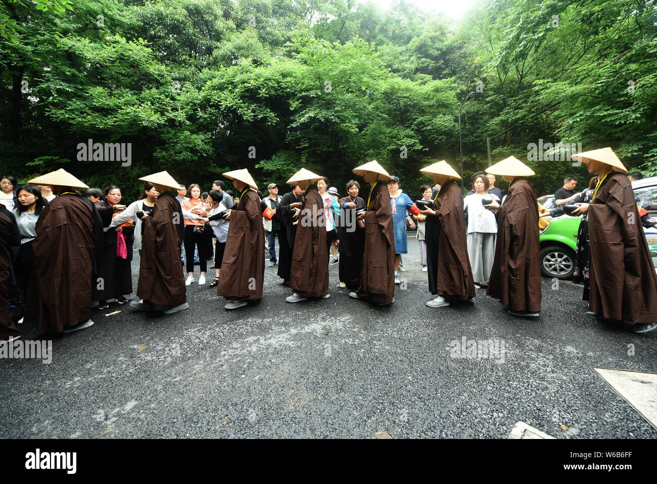 Chinese Buddhist monks holding alms bowls to receive donation from ...