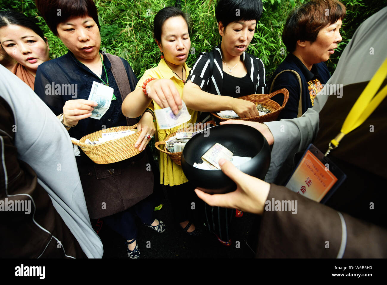 Chinese Buddhist monks holding alms bowls to receive donation from ...