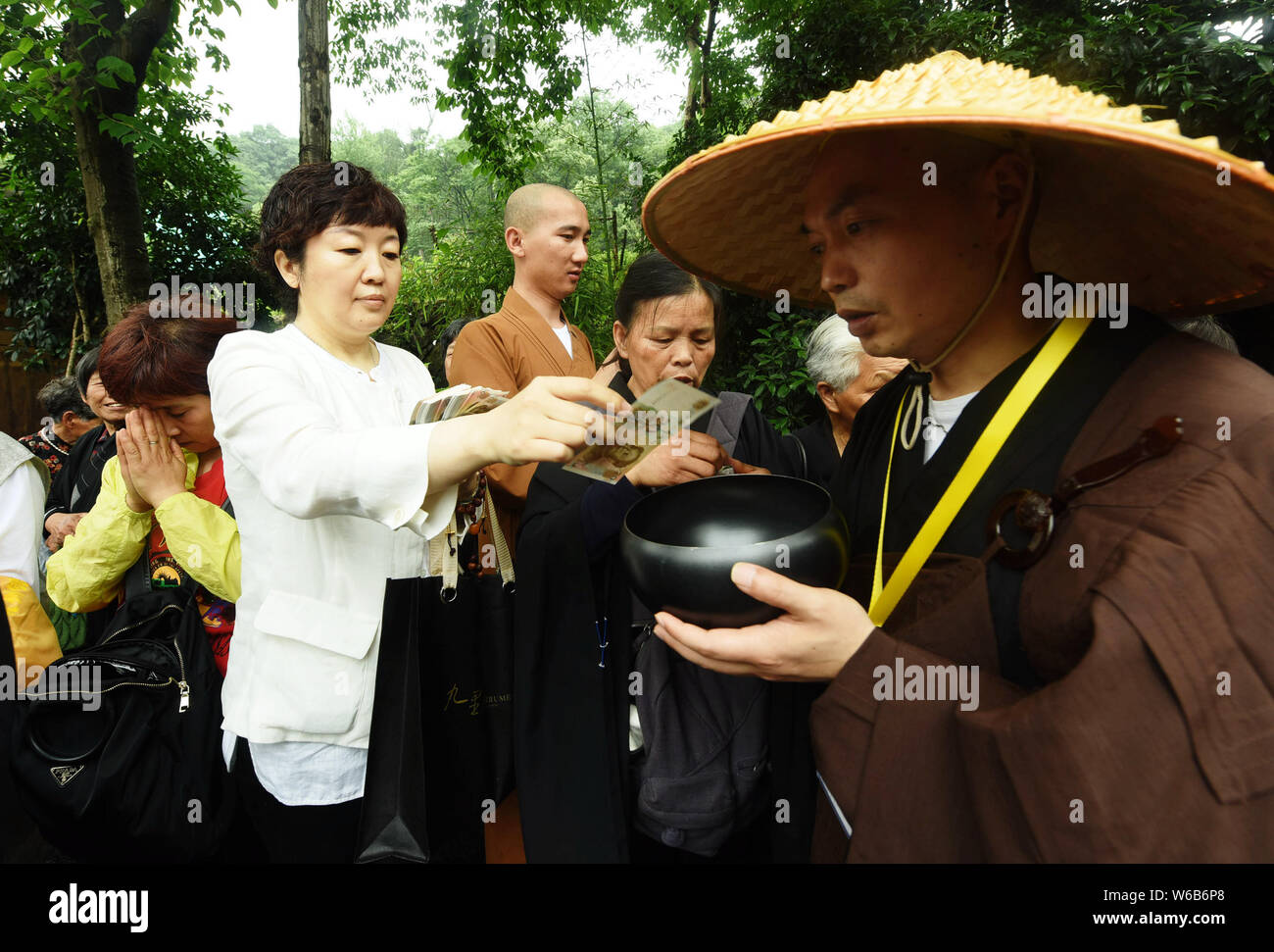 Chinese Buddhist monks holding alms bowls to receive donation from ...