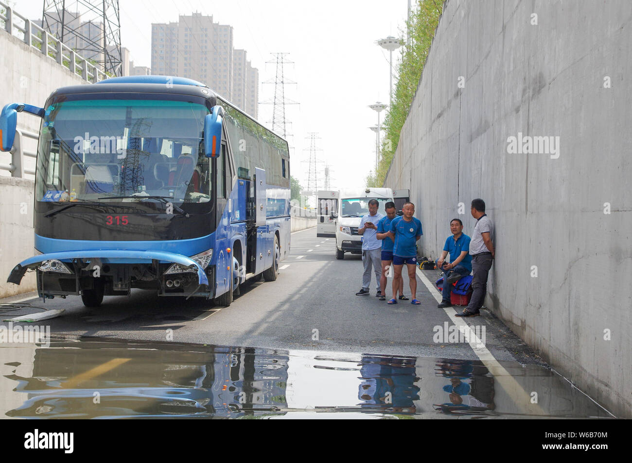 The bus which was stuck under a flooded bridge caused by heavy rain is ...