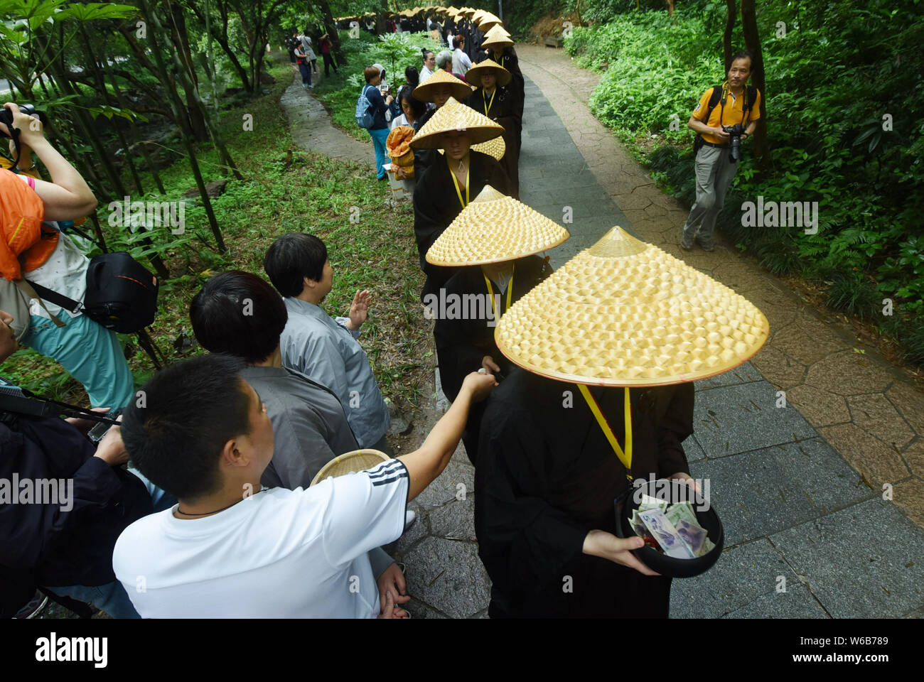 Chinese Buddhist monks holding alms bowls to receive donation from ...