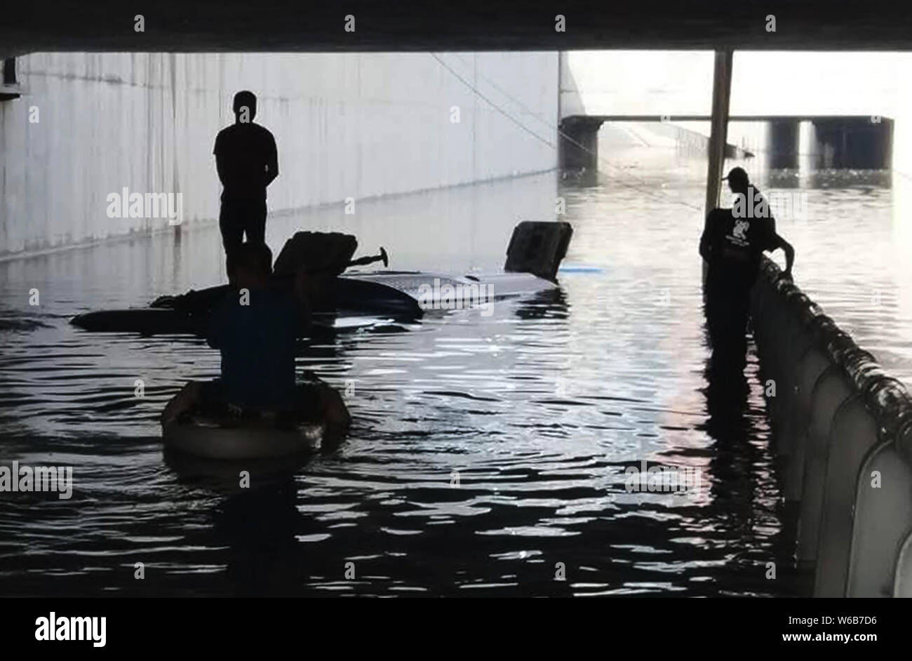 View of a submerged bus stuck under a flooded bridge caused by heavy ...