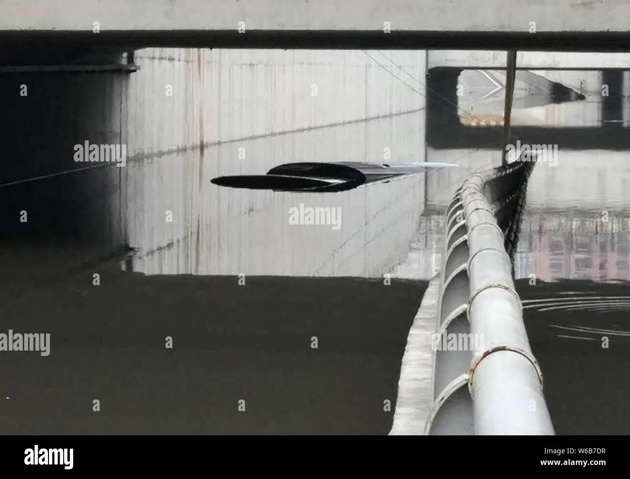View of a submerged bus stuck under a flooded bridge caused by heavy ...