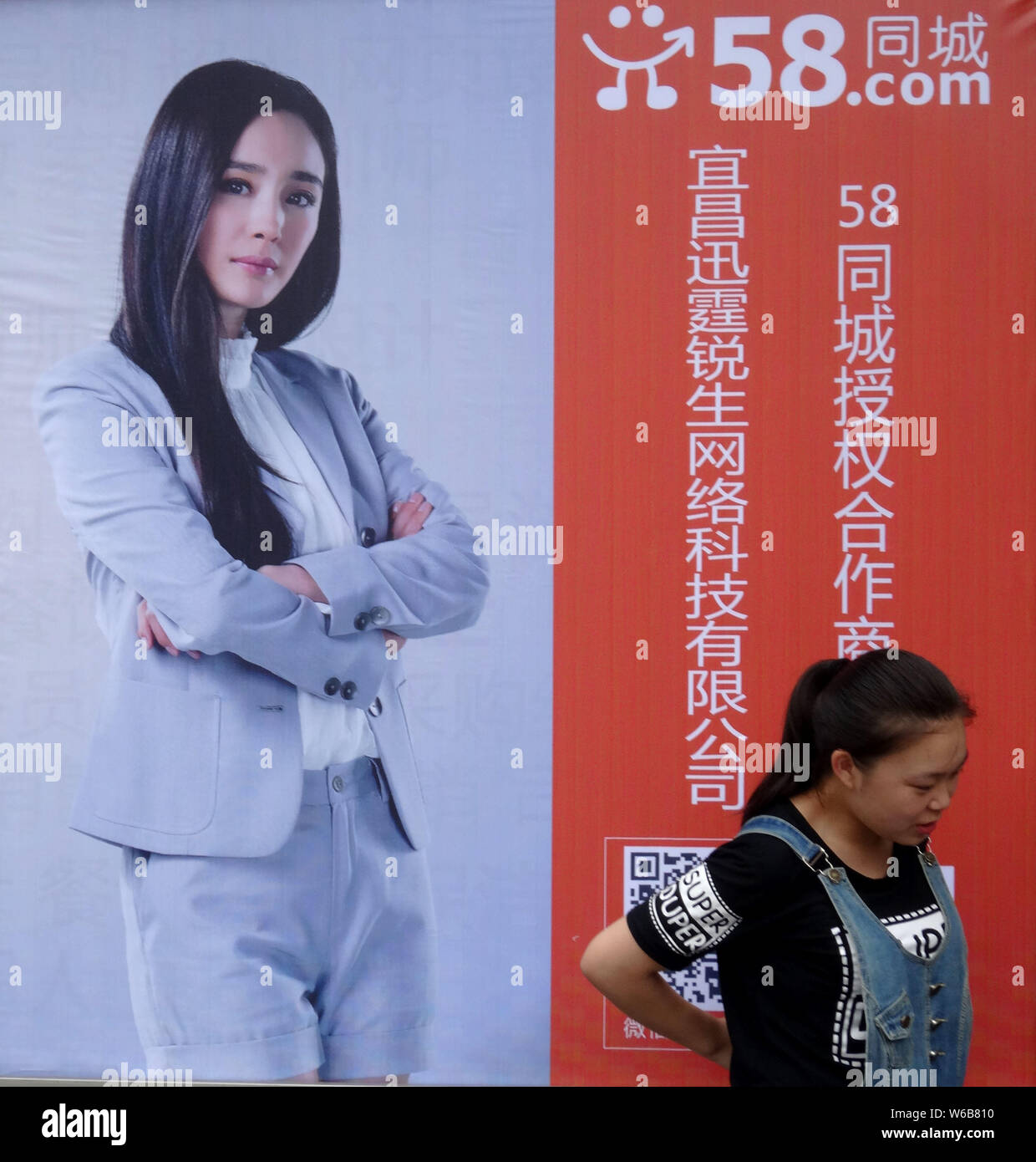 --FILE--A pedestrian walks past an advertisement of Chinese online classified site 58.com ...