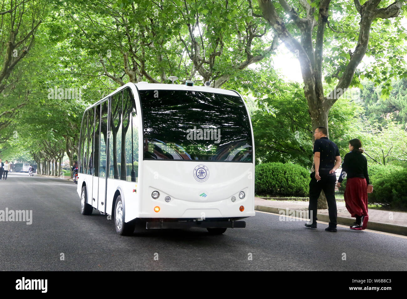 A driverless mini bus runs on a road at the campus of the Shanghai Jiao ...