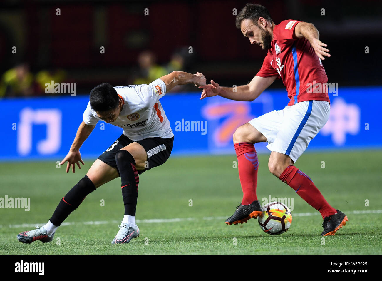 Spanish football player Cala, right, of Henan Jianye kicks the ball to ...