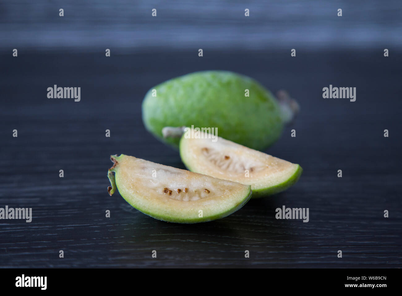 Homegrown organic feijoas. Whole fruit and cut fruit. Rough green skin ...