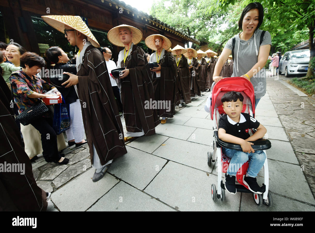 Chinese Buddhist monks holding alms bowls to receive donation from ...
