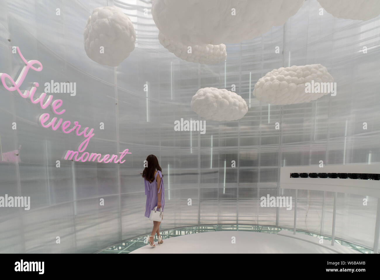 A tourist enjoys herself in a white cube installation with 22 SLR ...