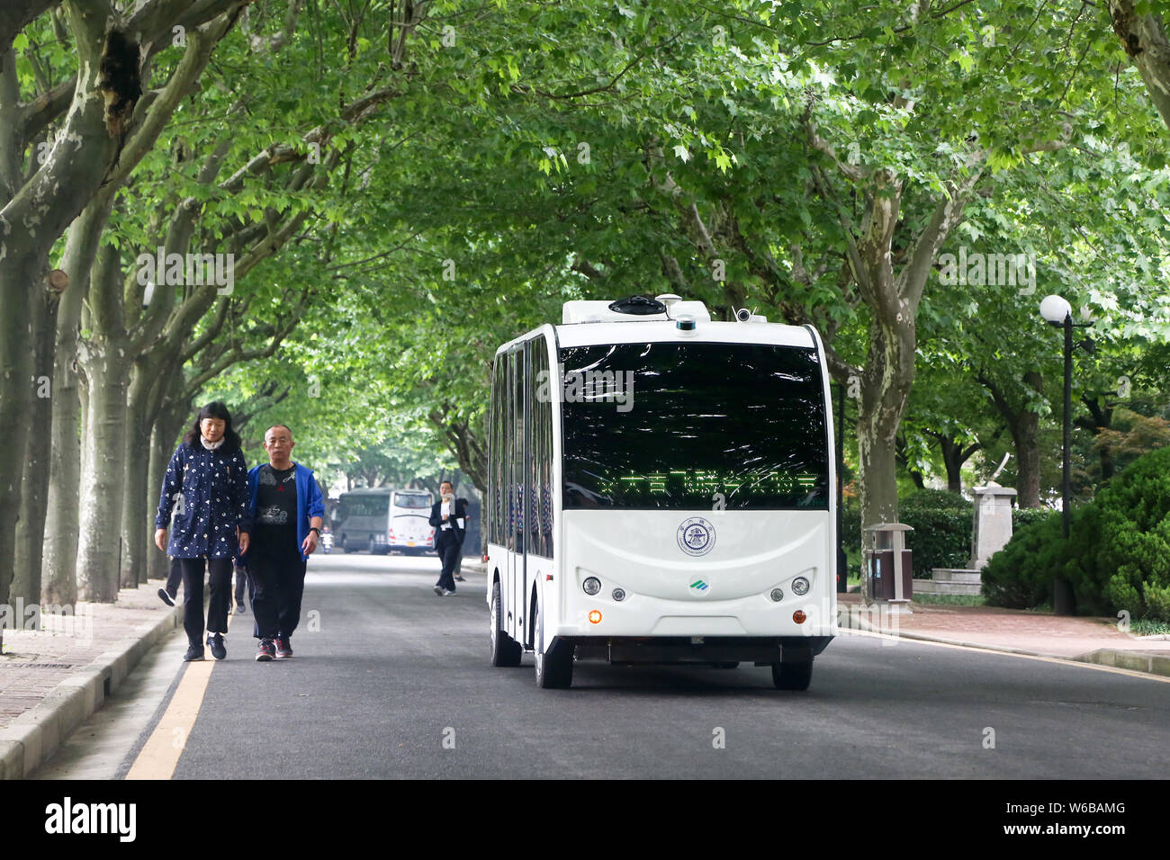 A driverless mini bus runs on a road at the campus of the Shanghai Jiao ...