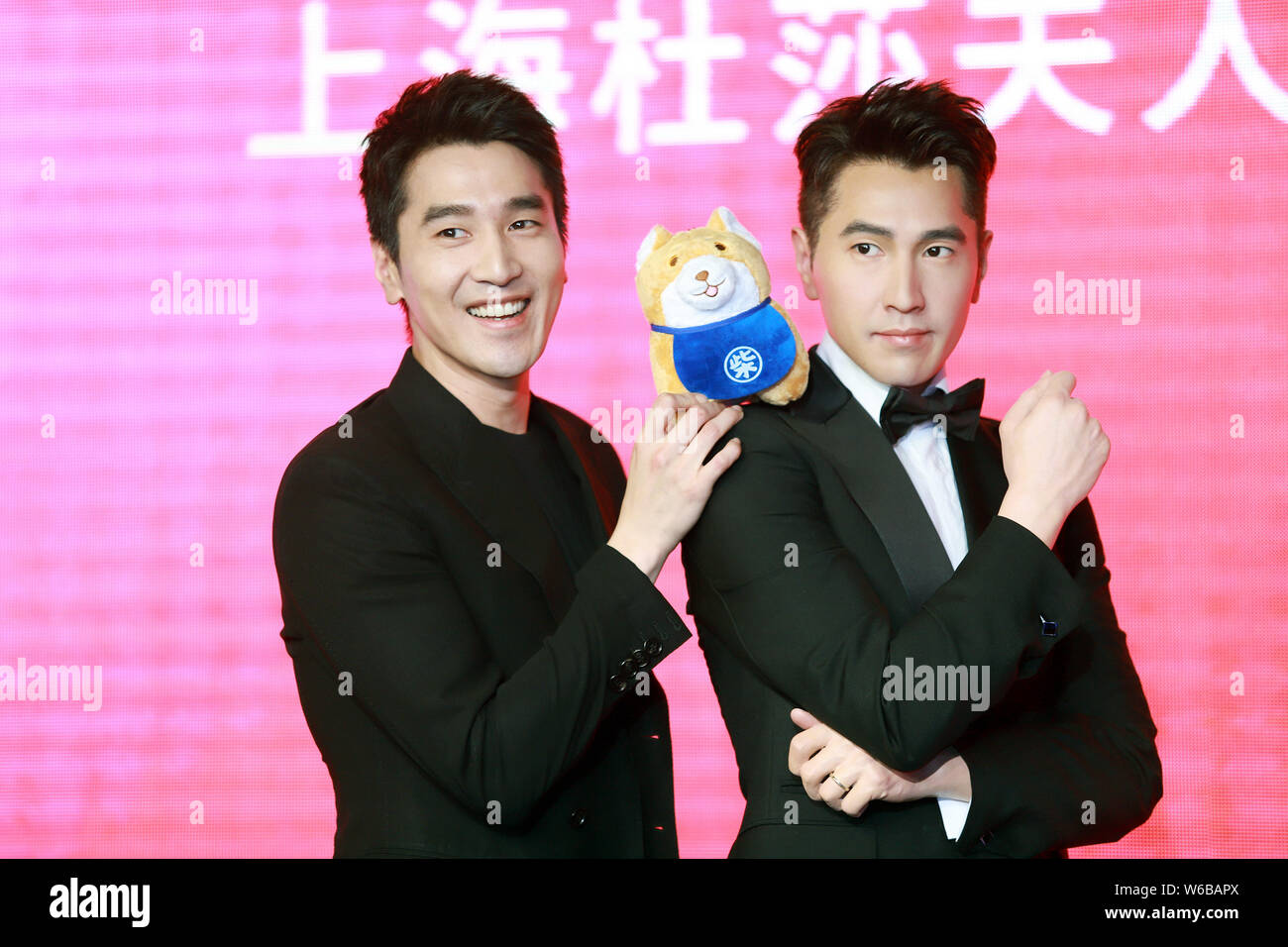 Taiwanese-Canadian actor Mark Chao, left, poses with a wax figure of ...