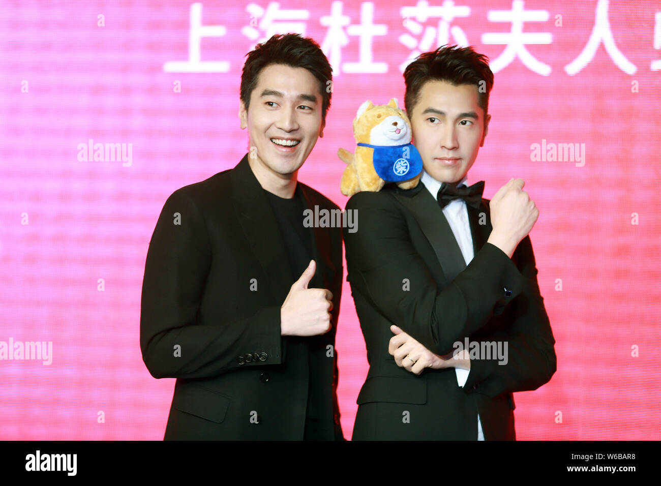 Taiwanese-Canadian actor Mark Chao, left, poses with a wax figure of ...