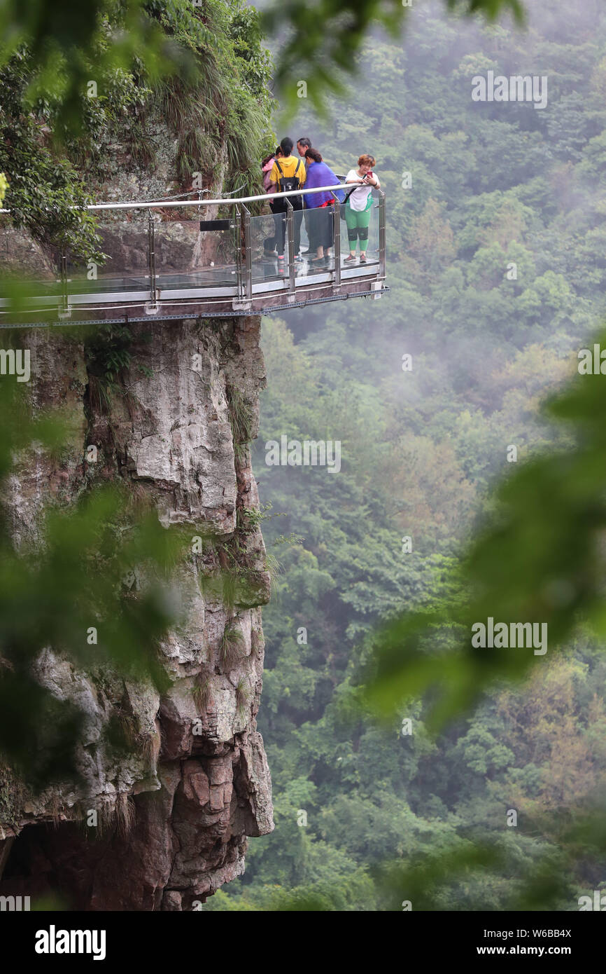 Tourists enjoy the scenery as they walk on the Lingyundu glass trestle ...